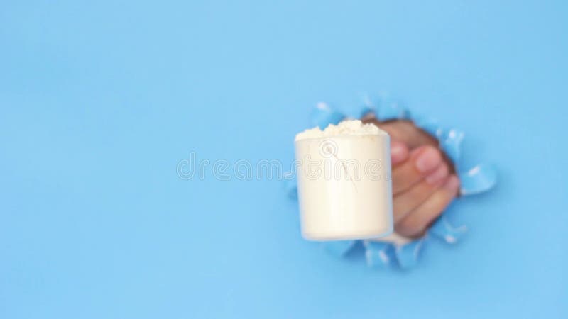 Woman`s Hand Holds Protein Shake on a Blue Background, Front View Stock ...