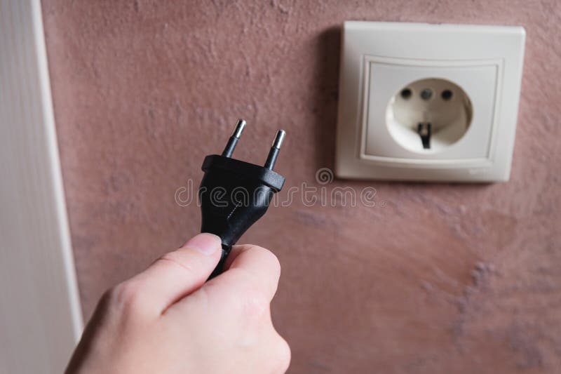 A Woman& X27;s Hand Inserts an Electric Plug into a Socket, Close-up ...