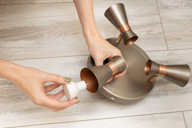 A Woman& X27;s Hand Inserts a Light Bulb into a Lamp Socket Stock Photo ...