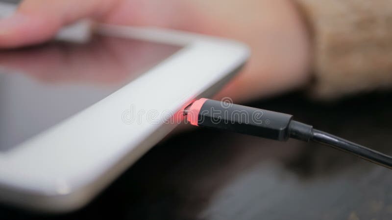 Woman`s Hand Plugging Black Lightning Charging Cable into Tablet Stock ...