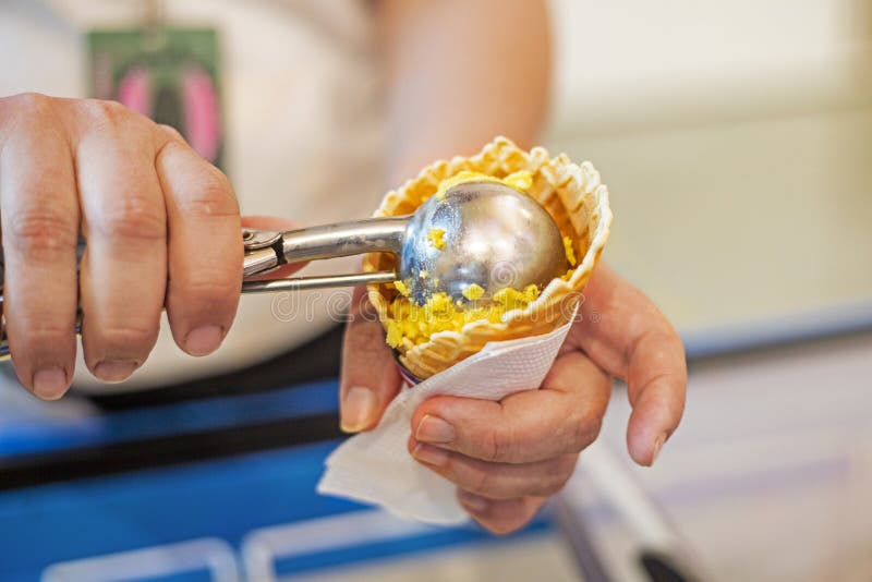 Woman S Hand Puts Portioned Mango Ice Cream into a Waffle Cup. Stock ...