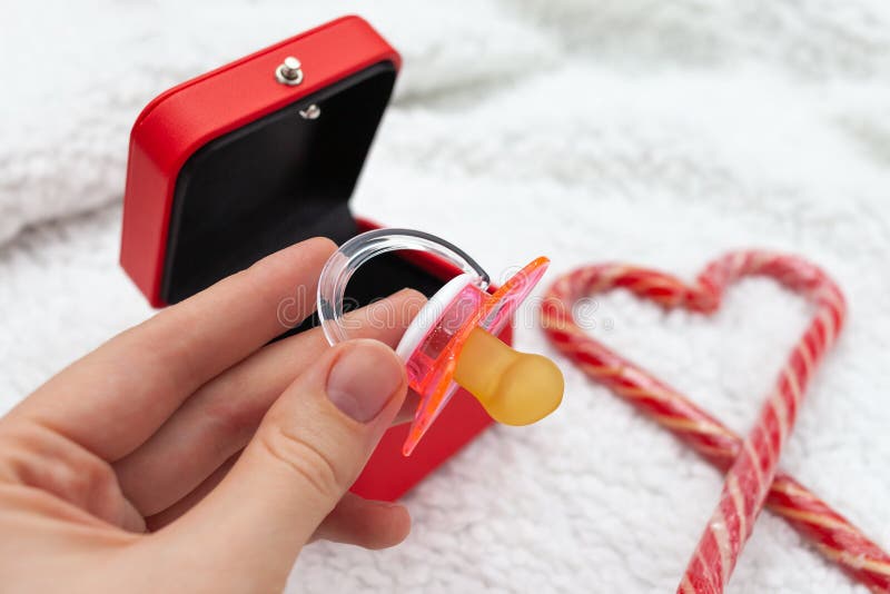 Woman`s Hand Takes a Pink Pacifier from a Red Gift Box Stock Image ...
