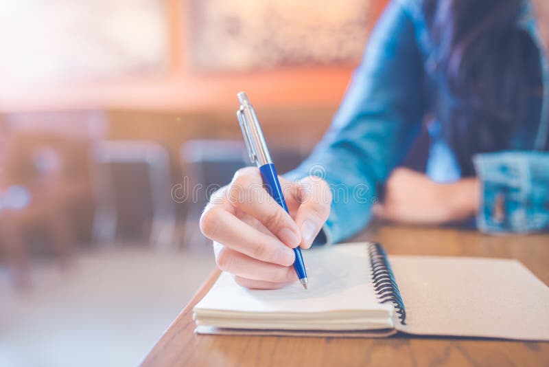 A Woman`s Hand is Writing in Empty Spiral Notepad with a Pen. Stock ...