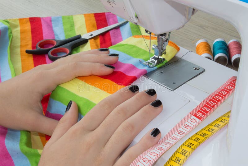 Woman`s Hands Using Sewing Machine with Reels of Colour Threads Stock ...