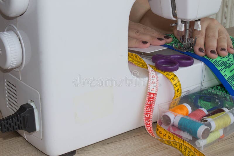 Woman`s Hands Using Sewing Machine with Reels of Colour Threads Stock ...