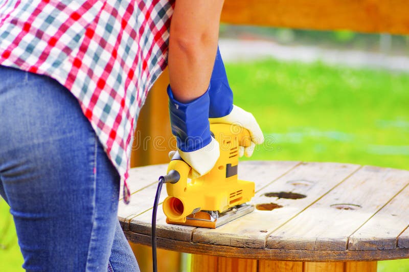 Woman Sanding a Wood Table with a Yellow Electric Sander Stock Photo ...