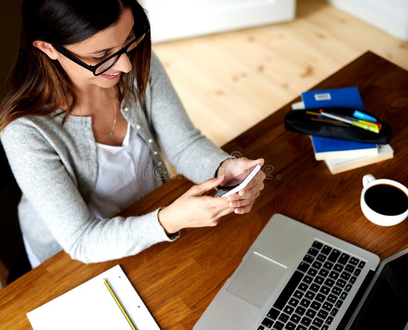 Woman Sat at Desk Looking at Mobile Phone Stock Image - Image of ...