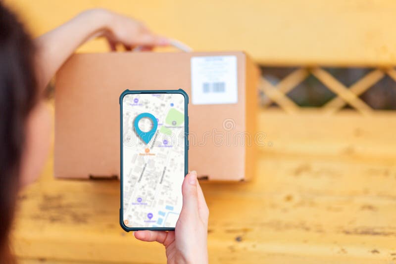 A Woman Scans the Parcel Code Using Her Smartphone. Online Map on the ...