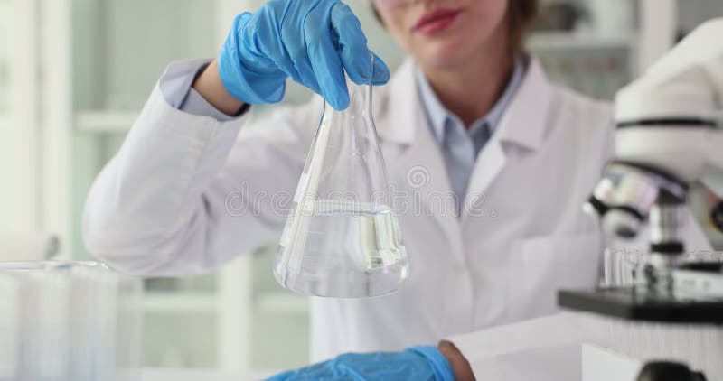 Woman Scientist Shakes Erlenmeyer Flask with Liquid Solution Stock ...