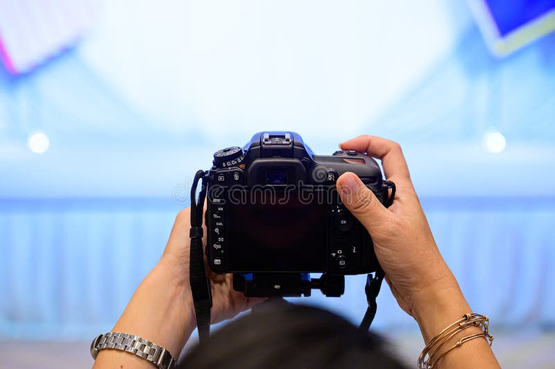 A Woman Setting Up Her Dslr Camera in Front of an Empty Stage Stock ...