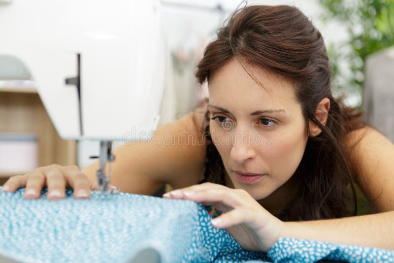 Woman sewing blue cloth stock photo. Image of industrial - 196684798