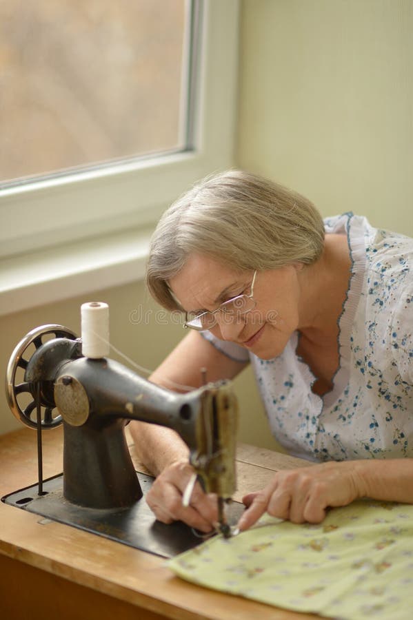 Woman Using Sewing Machine stock image. Image of house - 10320733