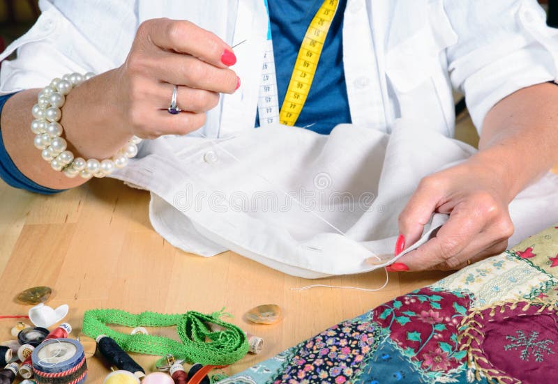 A woman sews a button stock photo. Image of female, woman - 45564176