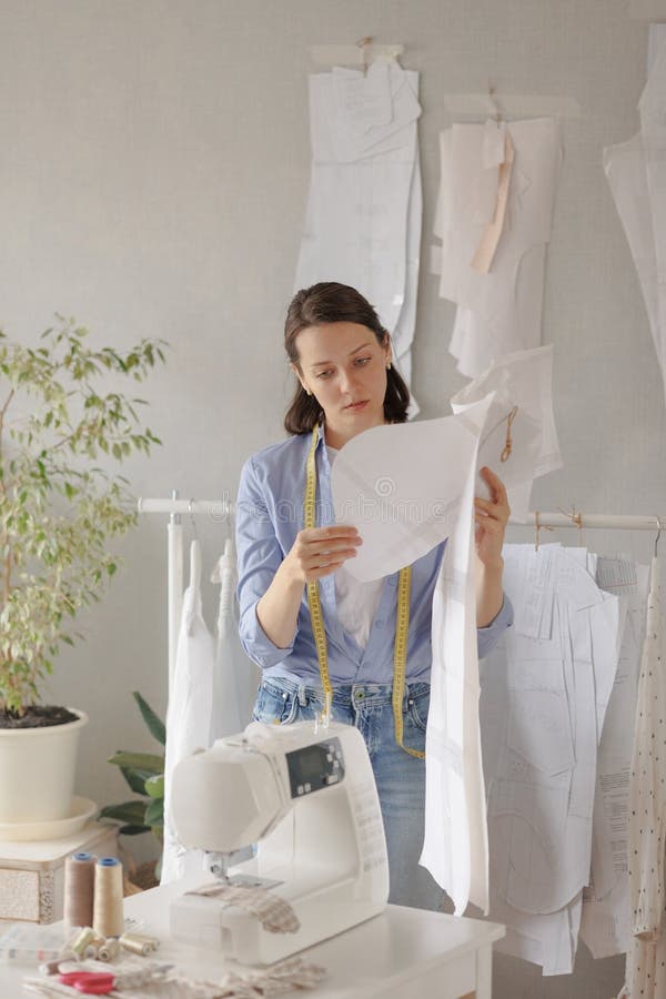 Woman Sews Clothes on a Sewing Machine in a Workshop. Work in the ...