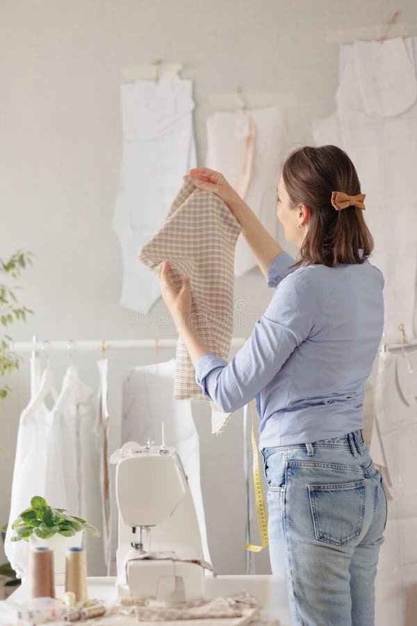 Woman Sews Clothes on a Sewing Machine in a Workshop. Work in the ...