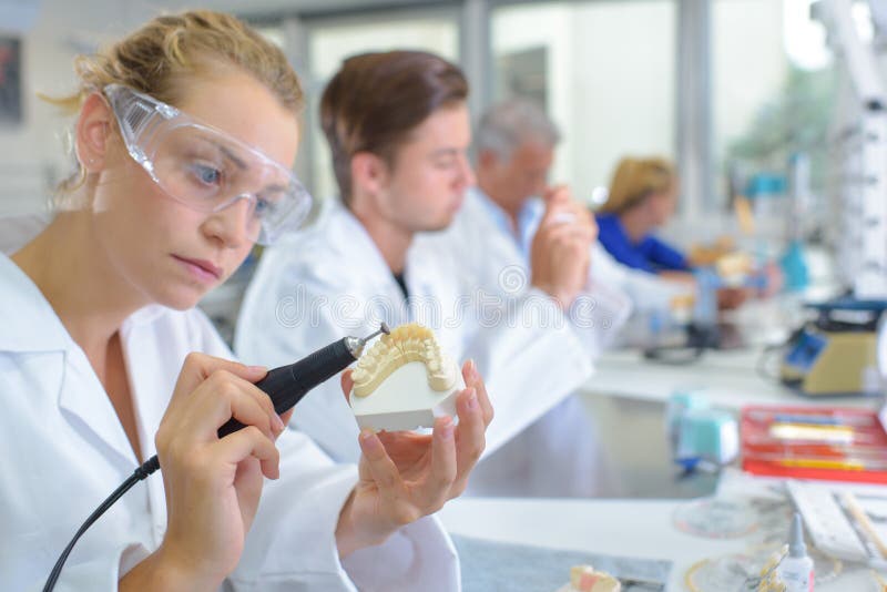 Woman Shaping False Teeth Using Electric Tool Stock Image - Image of ...