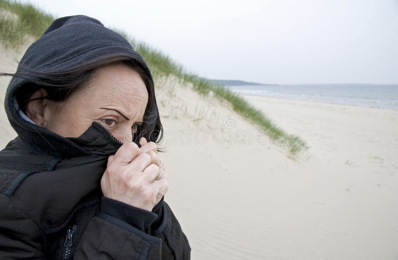 Woman shivering on beach stock photo. Image of beach - 24862754
