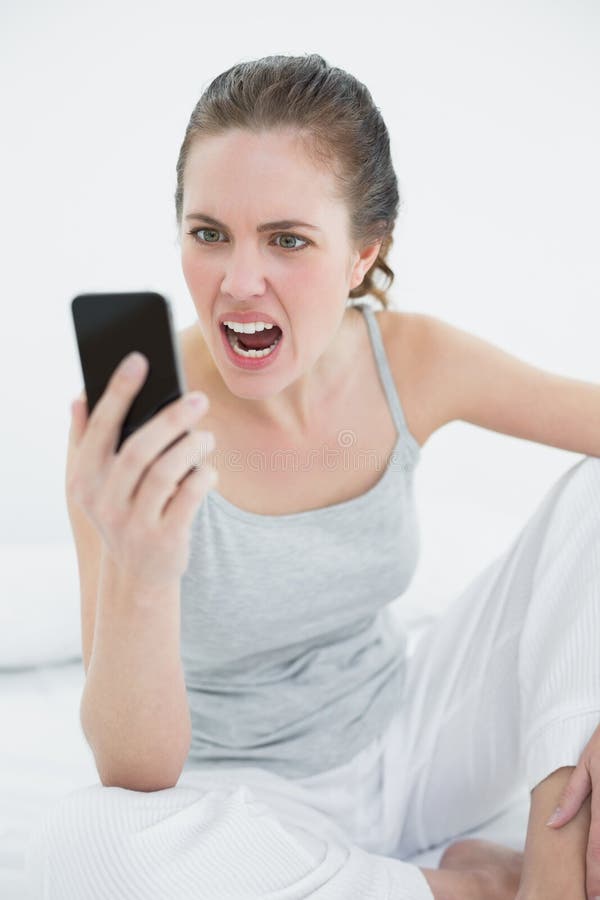 Woman Shouting into Mobile Phone in Bed Stock Image - Image of hair ...
