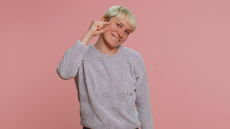Woman Showing a Little Bit Gesture with Sceptic Smile, Showing Minimum ... Woman Showing a Little Bit Gesture with Sceptic Smile, Showing Minimum ...
