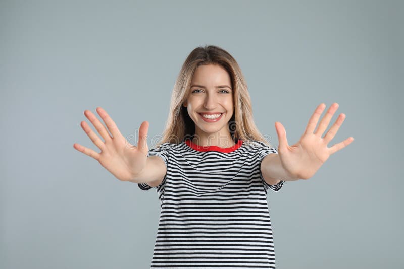 Woman Showing Number Ten with Her Hands on Light Grey Background Stock ...