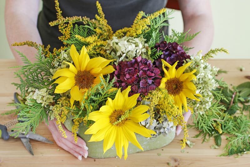 Woman Shows How To Make Floral Arrangement with Sunflowers and ... Woman Shows How To Make Floral Arrangement with Sunflowers and ...