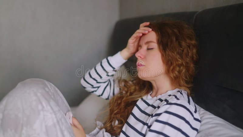 Woman Sick With Flu Coughing And Blowing Her Nose On Her Bed At Home