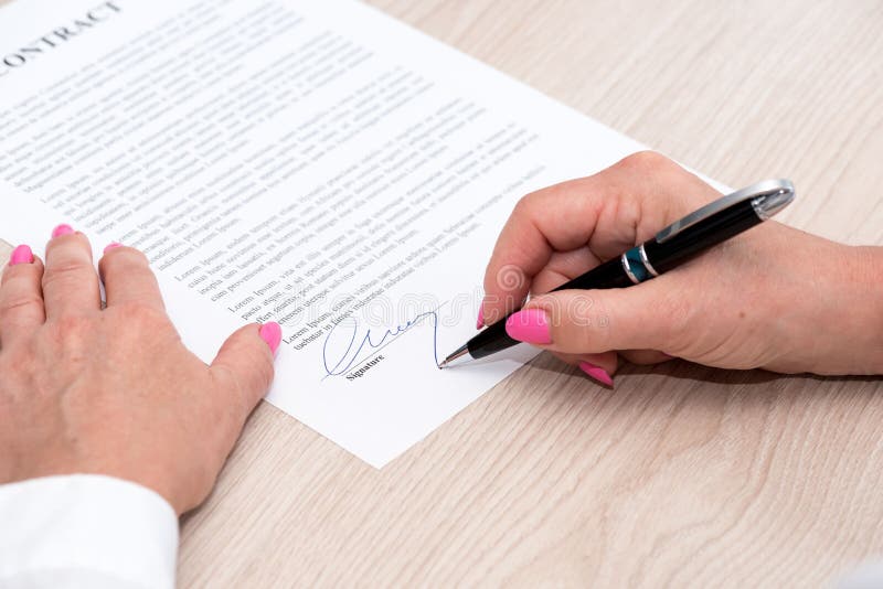 Woman signing a contract stock photo. Image of signature - 102548900