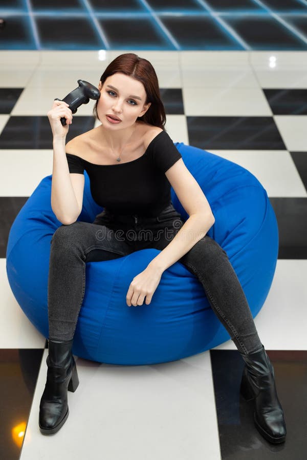 Woman Sits in a Chair and Plays Video Games Console VR with an ...