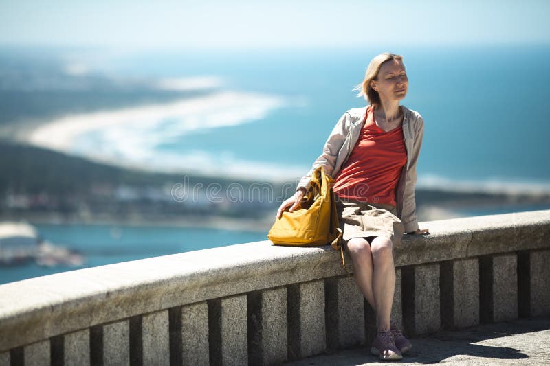 A Woman Sits on an Observation Deck on the Shore of the Atlantic Ocean ...
