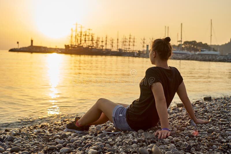 Woman Sitting on the Beach and Watching the Sunset Stock Image - Image ...