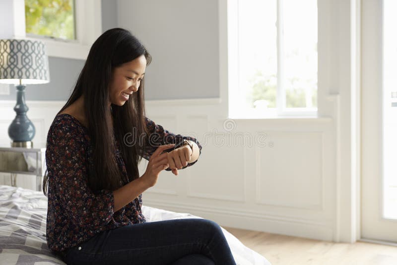Woman Sitting on Bed in Bedroom Checking Smart Watch Stock Image ...