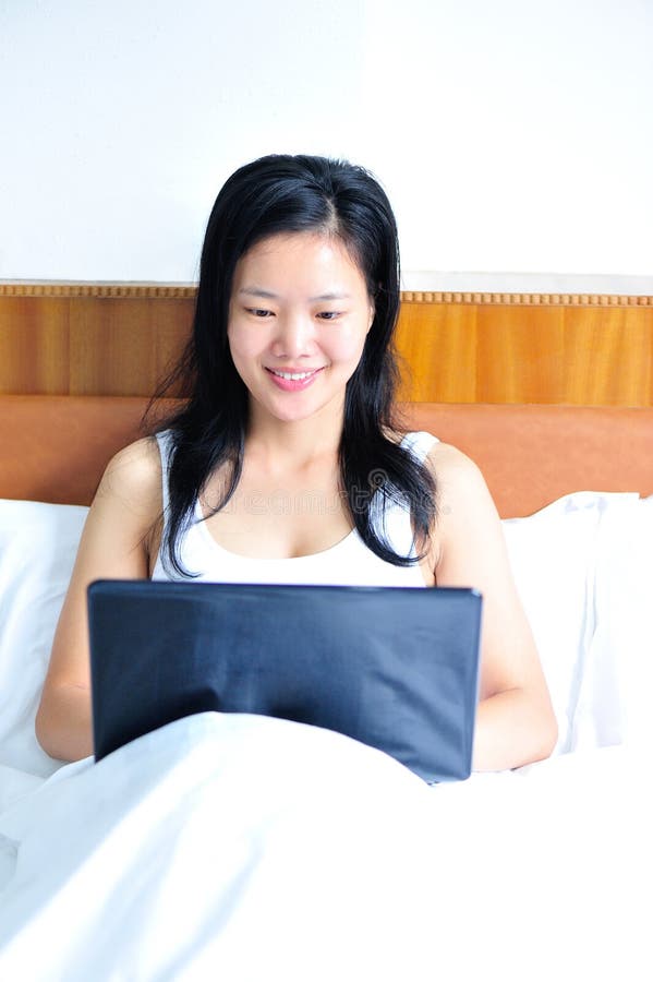 Woman Sitting on the Bed Using Her Computer Stock Image - Image of ...