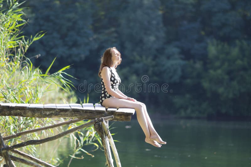 A Woman Sitting on a Bridge Stock Photo - Image of swimsuit, sunlight ...