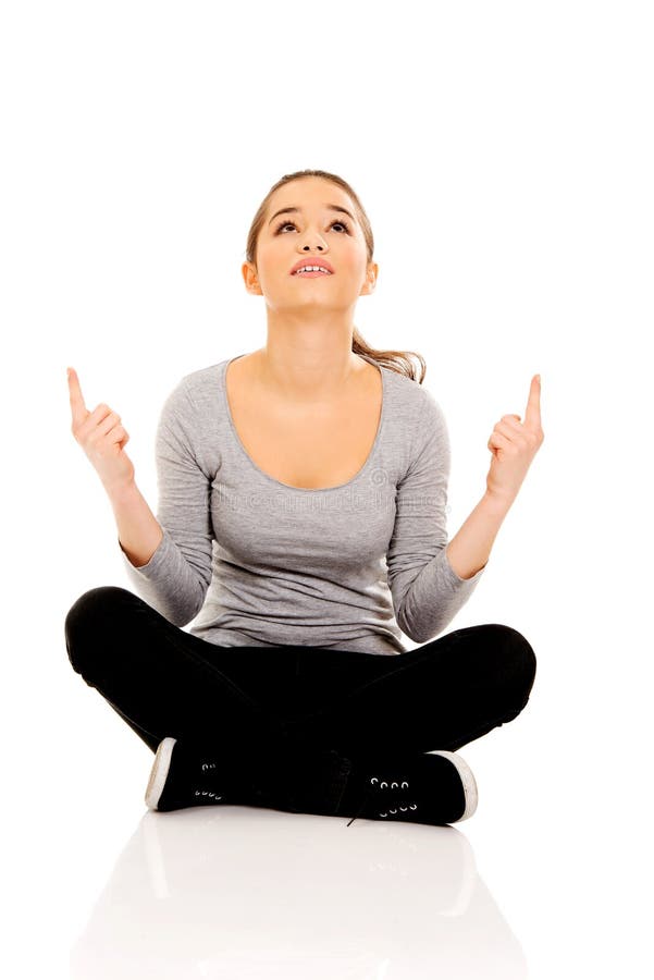 Woman Sitting Cross Legged Pointing Up. Stock Photo - Image of ...