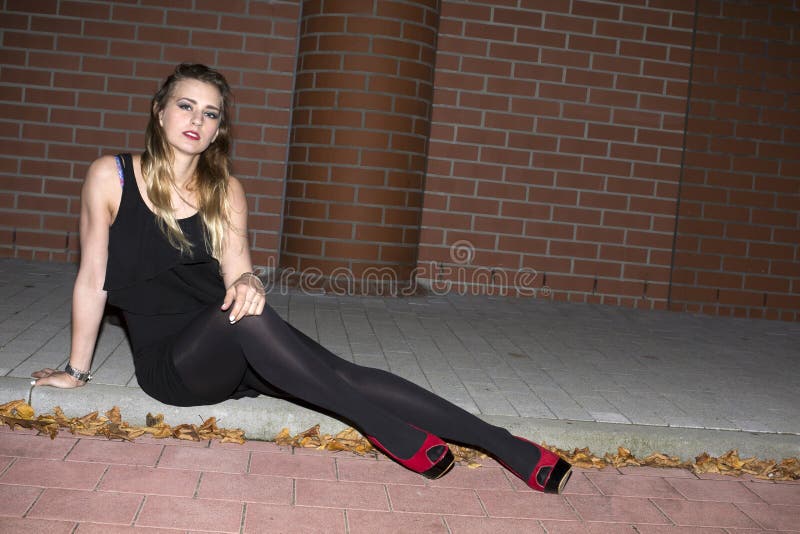 Woman sitting on a curb stock image. Image of street - 46418593