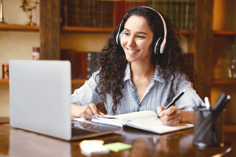 Woman Sitting at Desk, Using Laptop and Writing in Notebook Stock Image ...