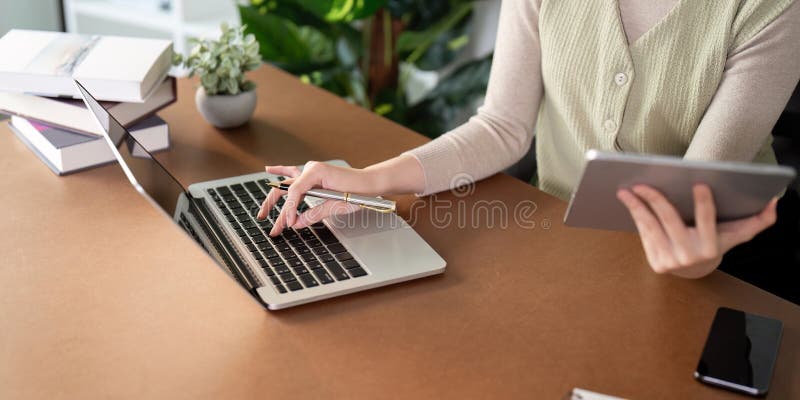 Woman Sitting at Desk and Working at Computer Laptop and Tablet PC at ...