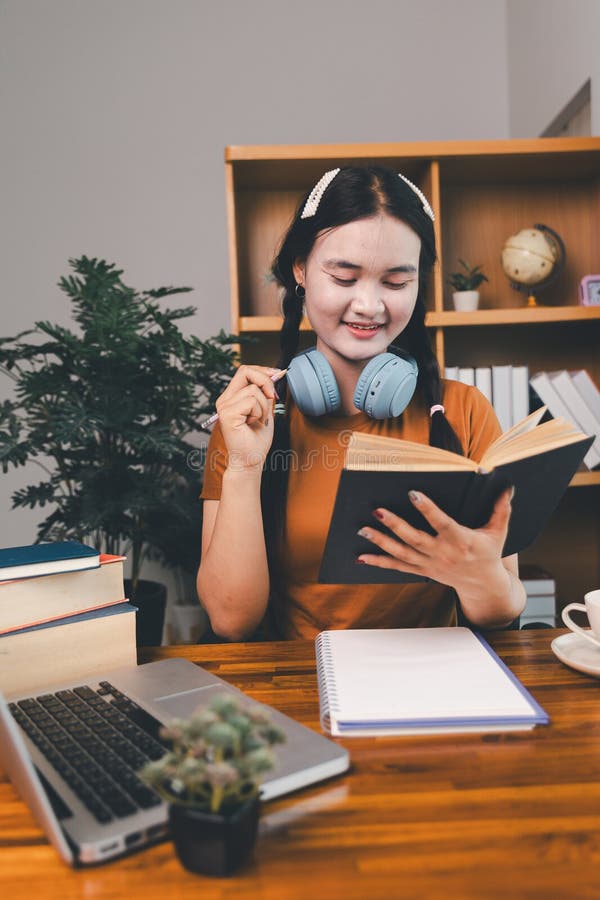 Woman Sitting at Desk Working on Laptop Taking Notes in Notebook ...
