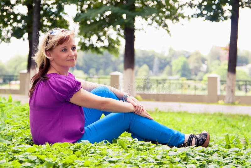 Woman sitting on the grass stock photo. Image of mature - 26218004