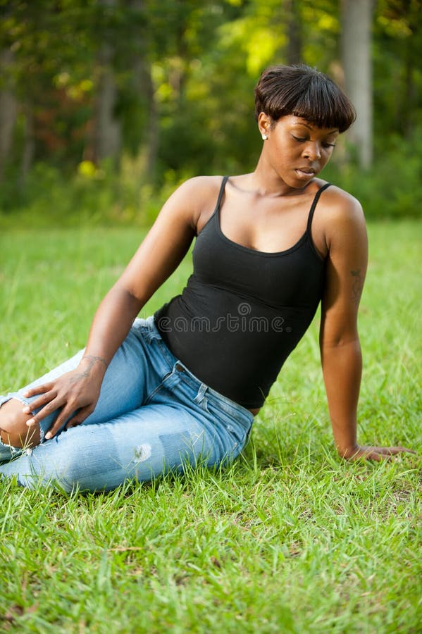 Woman sitting on the grass stock photo. Image of trees - 27696490
