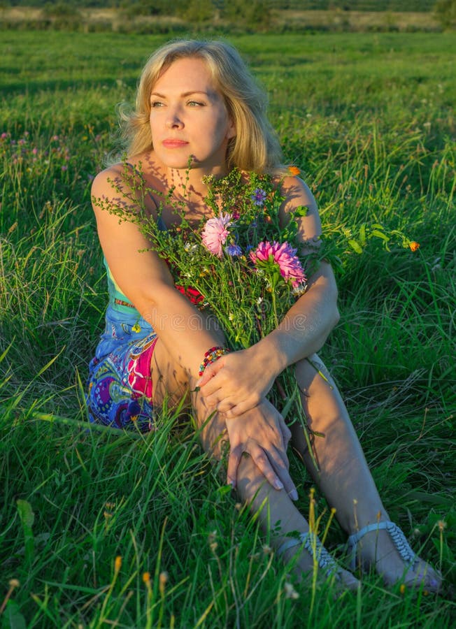 Woman Sitting On The Grass With Flowers Stock Image Image Of Mature