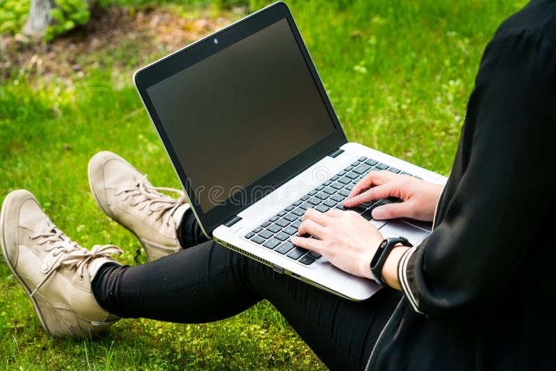 A Woman is Sitting on the Grass while Using Laptop Computer Stock Image ...