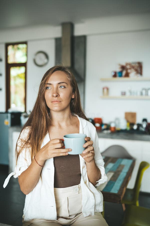 Woman Sitting in the Kitchen and Drinking Coffee Stock Image - Image of ...