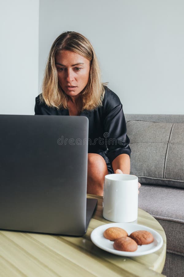 Woman Sitting With Laptop On Couch In The Morning Working At Home