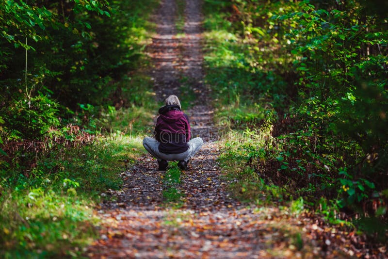 Woman Sitting on a Path between Trees in a Forest Stock Image - Image ...