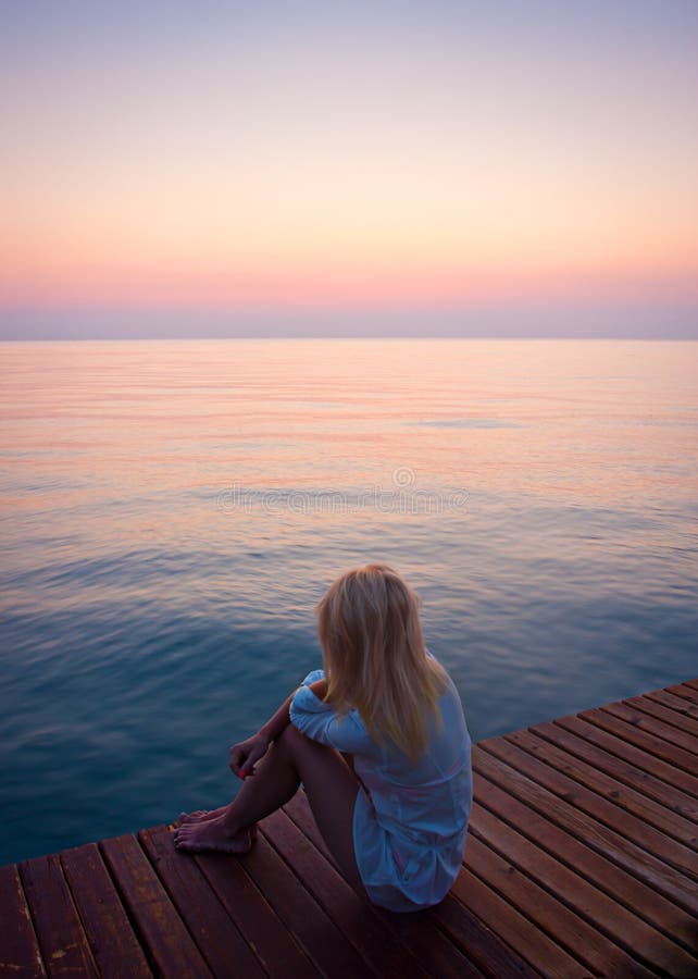 Woman Sitting on Pier at Sunrise Stock Photo - Image of space, water ...