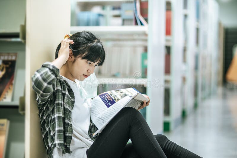 A Woman Sitting Reading a Book in the Library Stock Photo - Image of ...
