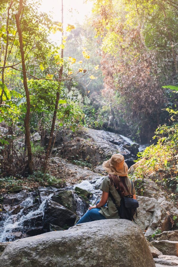 A Woman Sitting on the Rock in Front of Waterfall Stock Image - Image ...