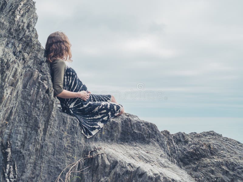 Woman Sitting on Rocks by the Sea Stock Image - Image of contemplate ...