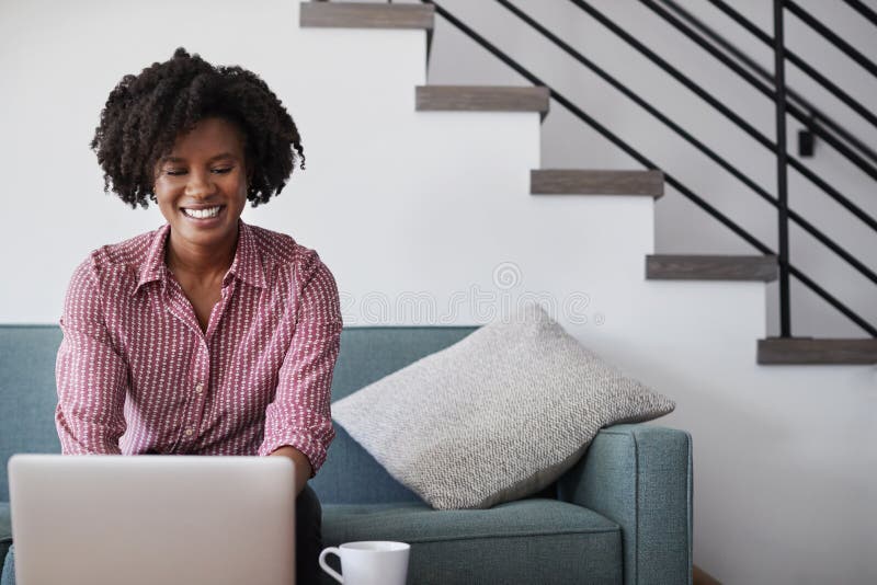 Woman Sitting on Sofa at Home Using Laptop Computer Stock Image - Image ...